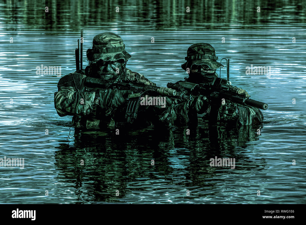 Pair of soldiers in action during a river raid in the jungle at night ...