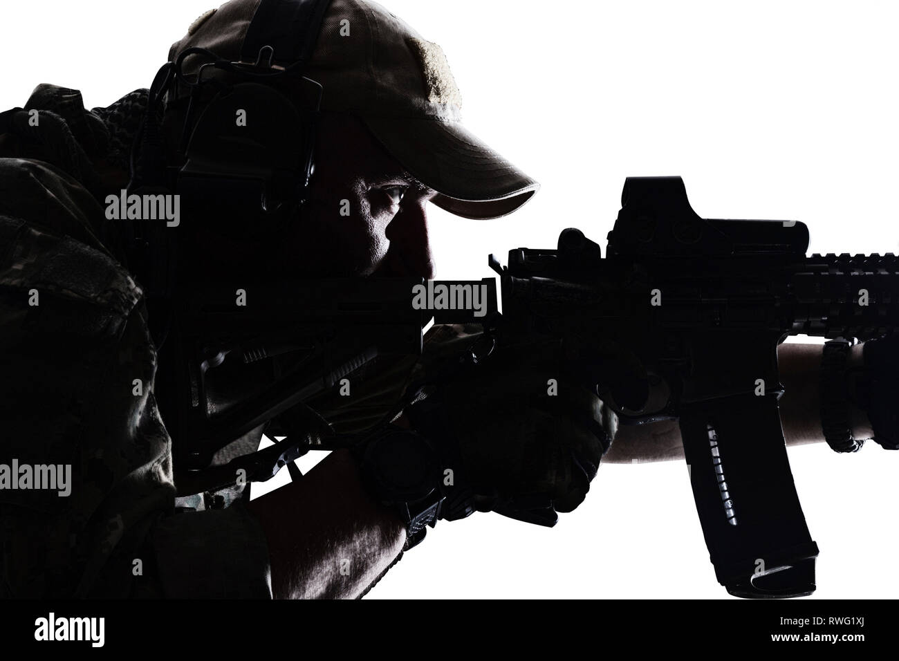Close-up of a special forces soldier in baseball cap, pointing rifle ...
