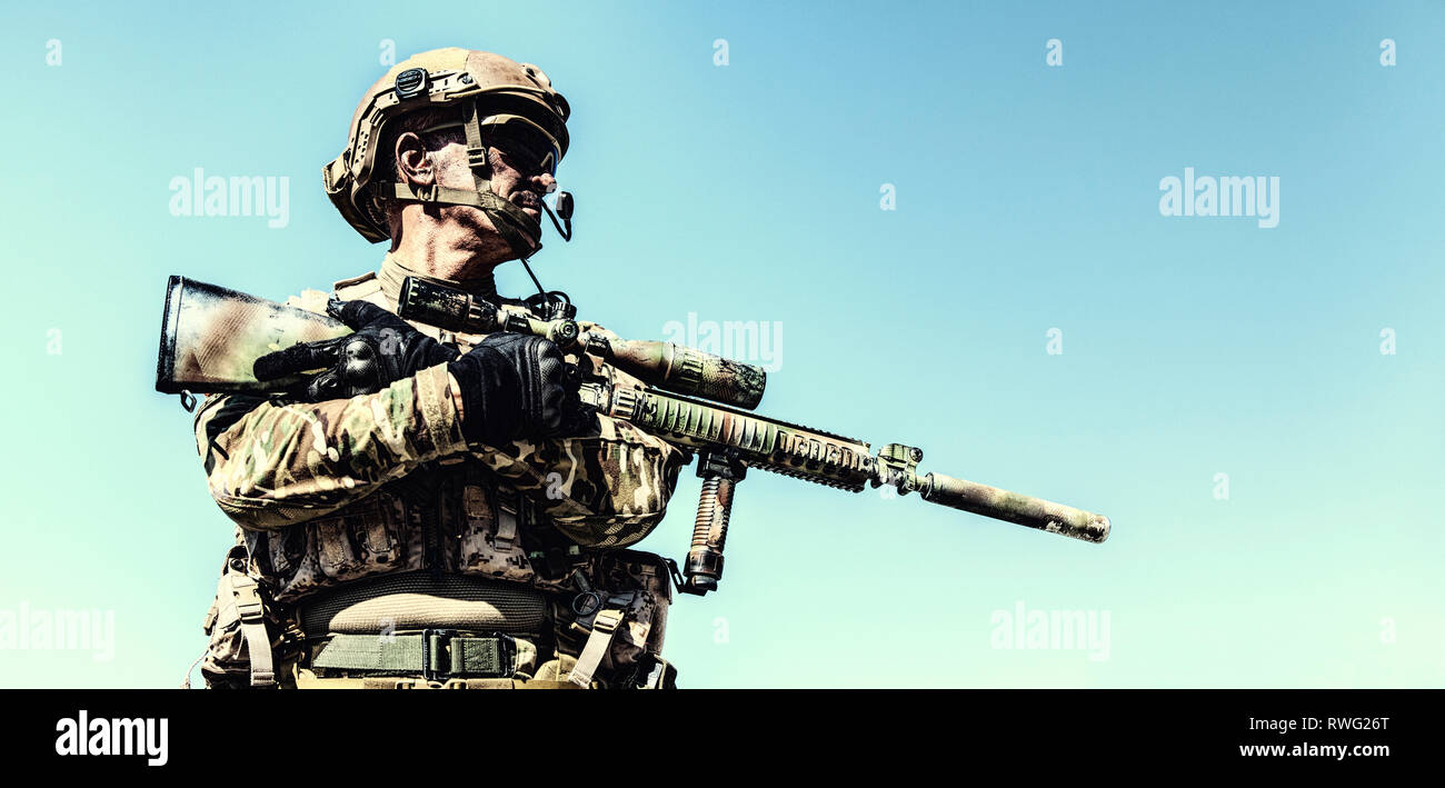 Low angle view of special forces soldier in field uniform with weapon ...