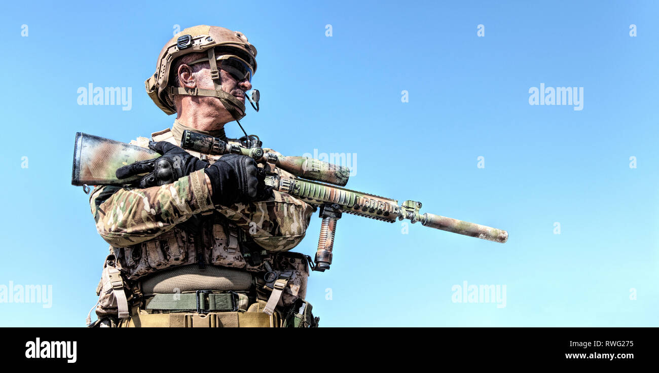 Low angle view of special forces soldier in field uniform with weapon ...
