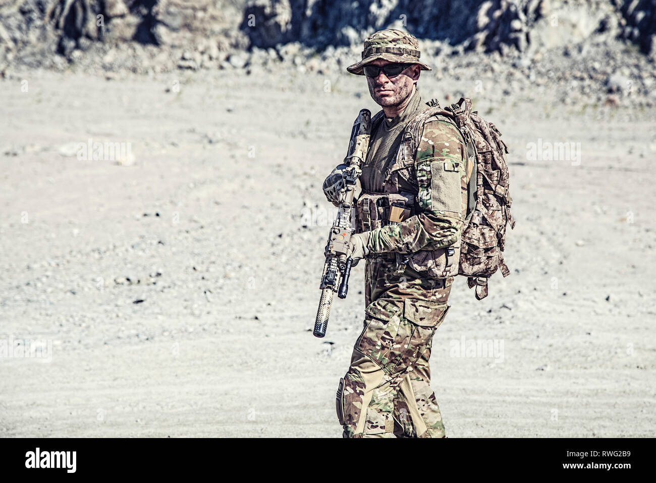 Soldier in field uniform with rifle in the desert Stock Photo - Alamy