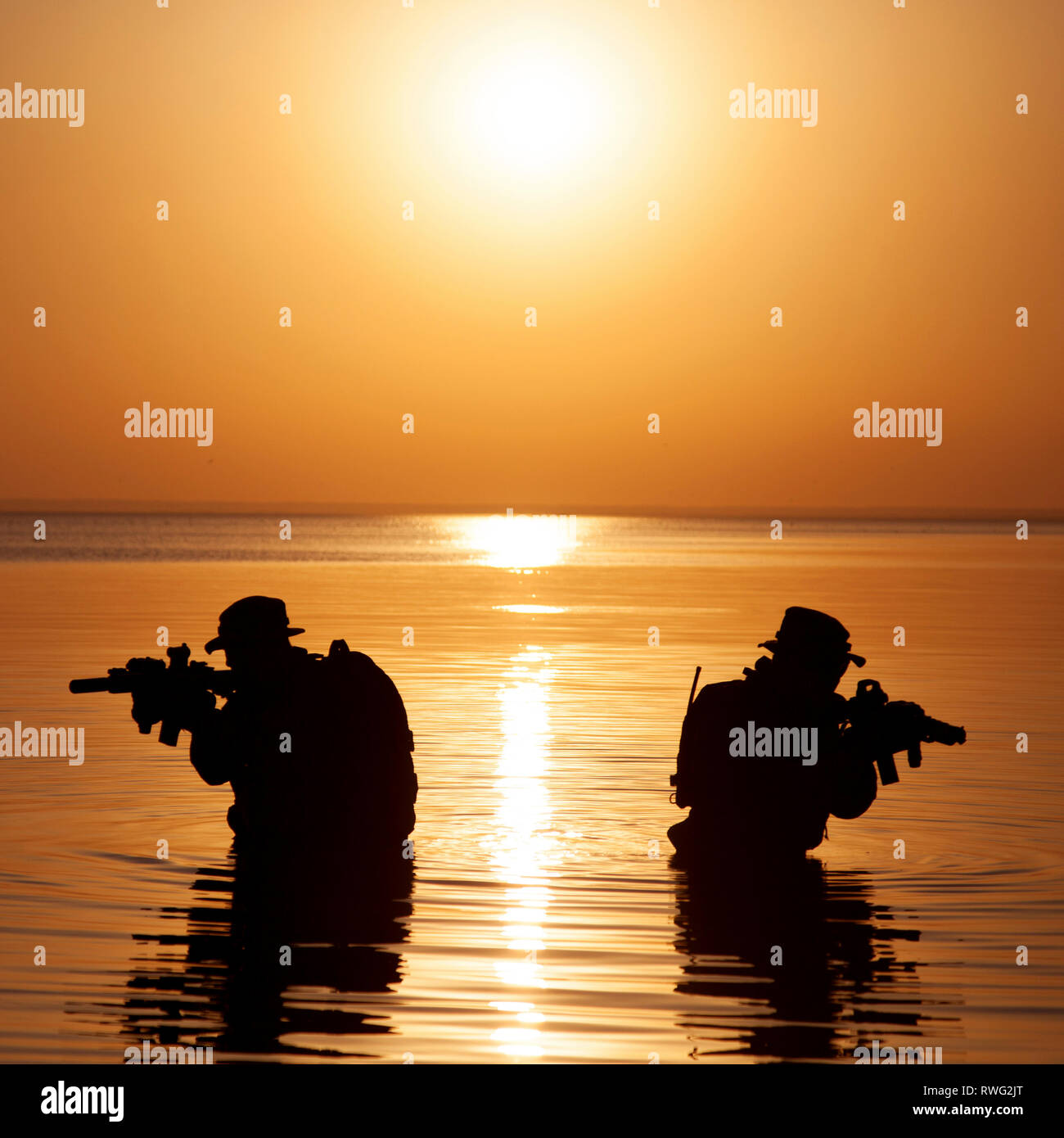 Silhouette of Army soldiers crossing a river at sunset Stock Photo - Alamy