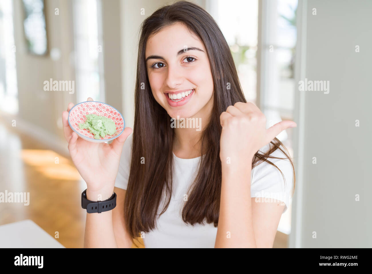 Beautiful young woman holding spicy asian wasabi pointing and showing ...