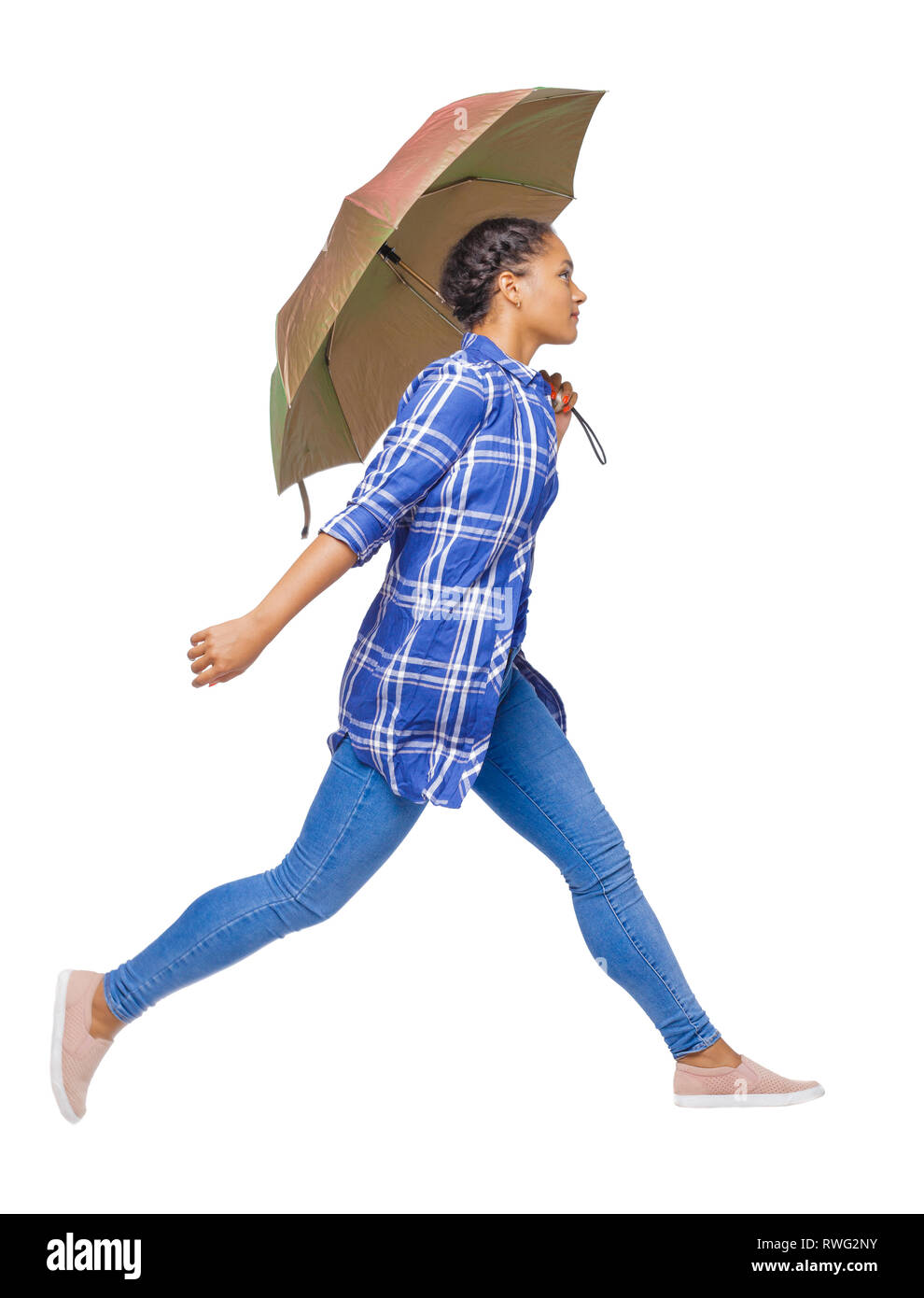 Side view of a woman balancing with an umbrella. girl jumps over a ...
