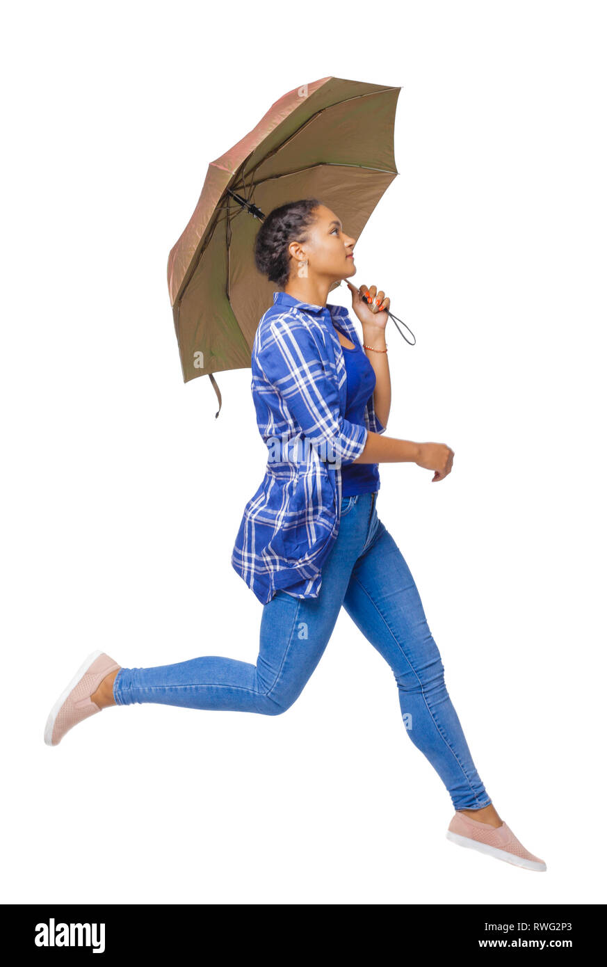 Side view of a woman balancing with an umbrella. girl jumps over a ...