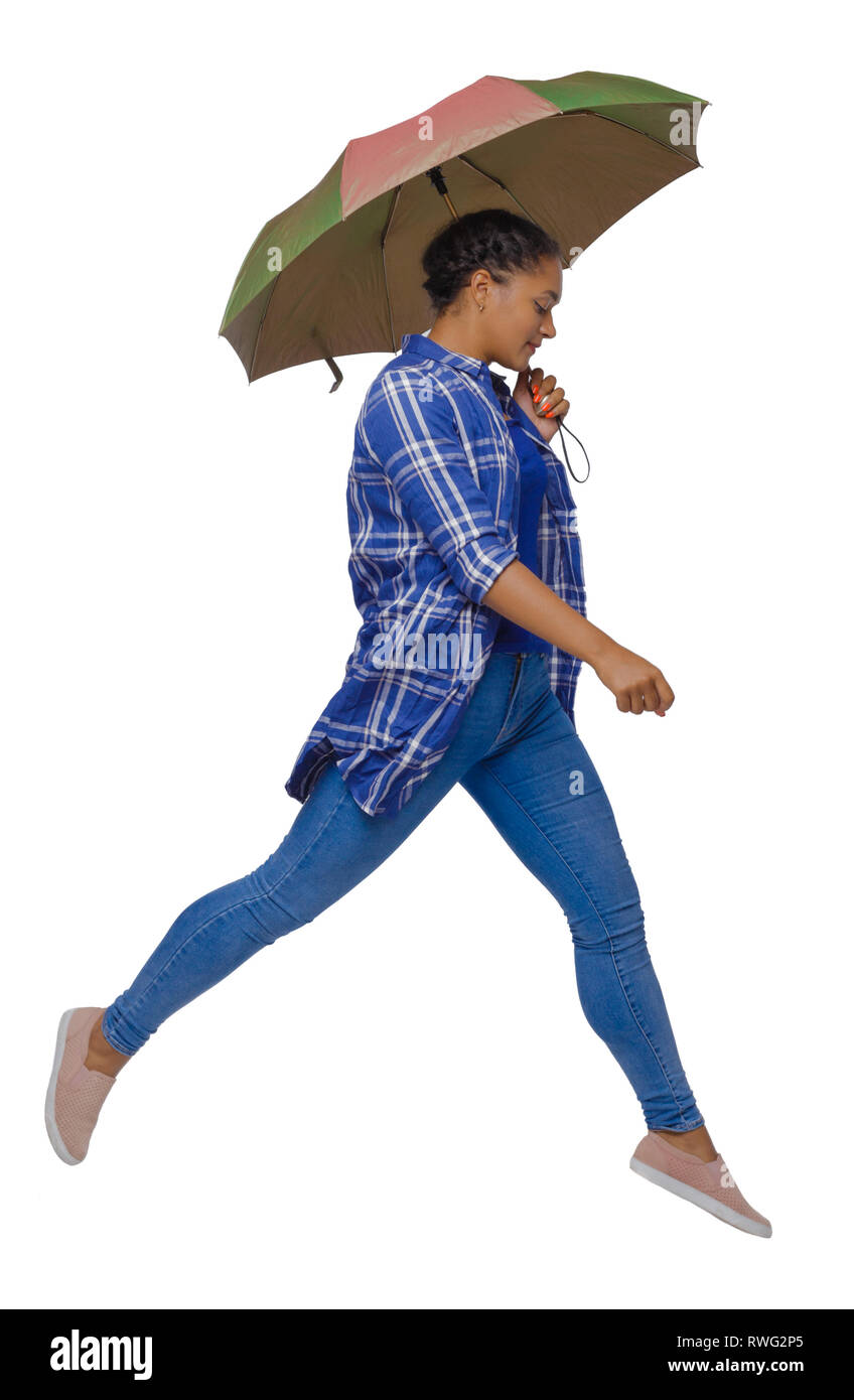 Side view of a woman balancing with an umbrella. girl jumps over a ...