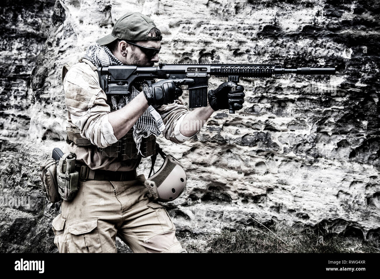 Private military contractor in baseball cap with assault rifle in the ...