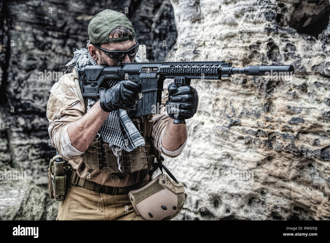 Private military contractor in baseball cap with assault rifle in the ...