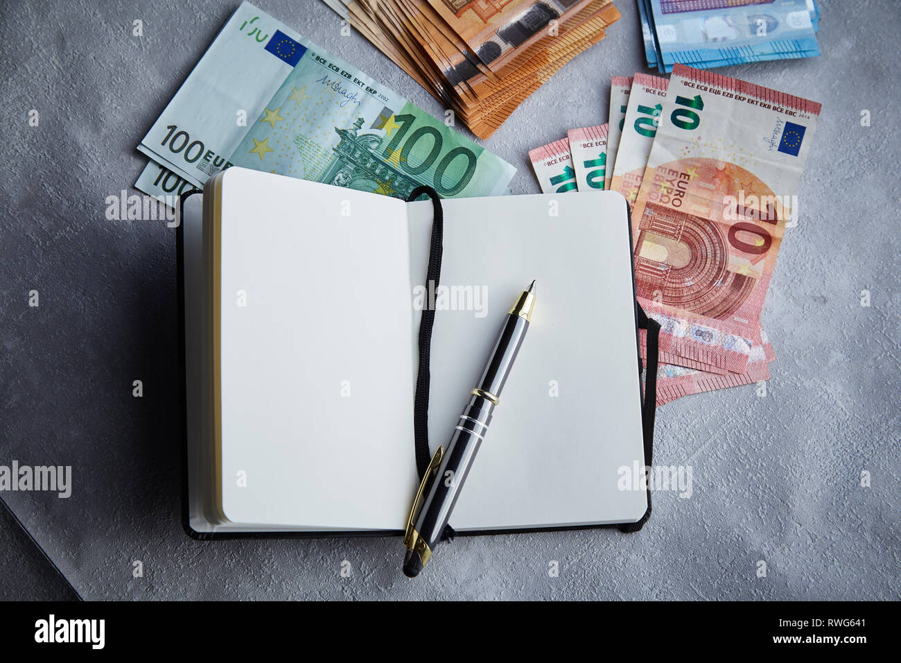Opened Notebook with lot of Euro Banknote on the Table Close -Up Top ...