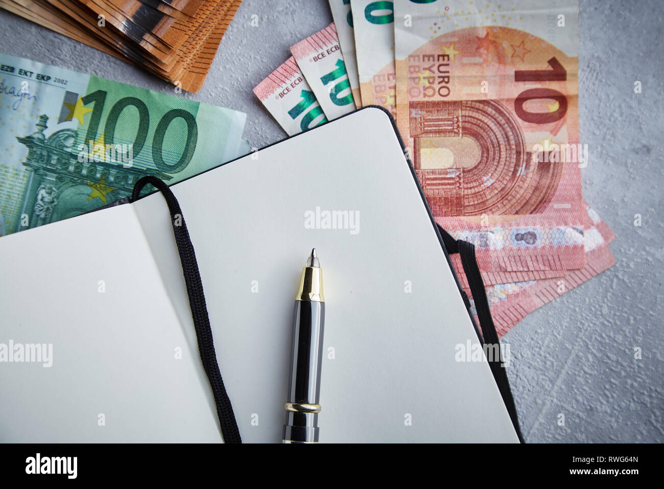Opened Notebook with lot of Euro Banknote on the Table Close -Up Top ...