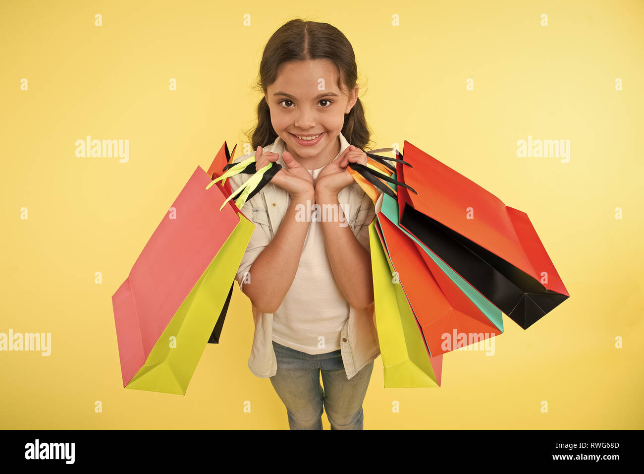 Fashion expert. Child cute shopping expert helps carry packages during ...
