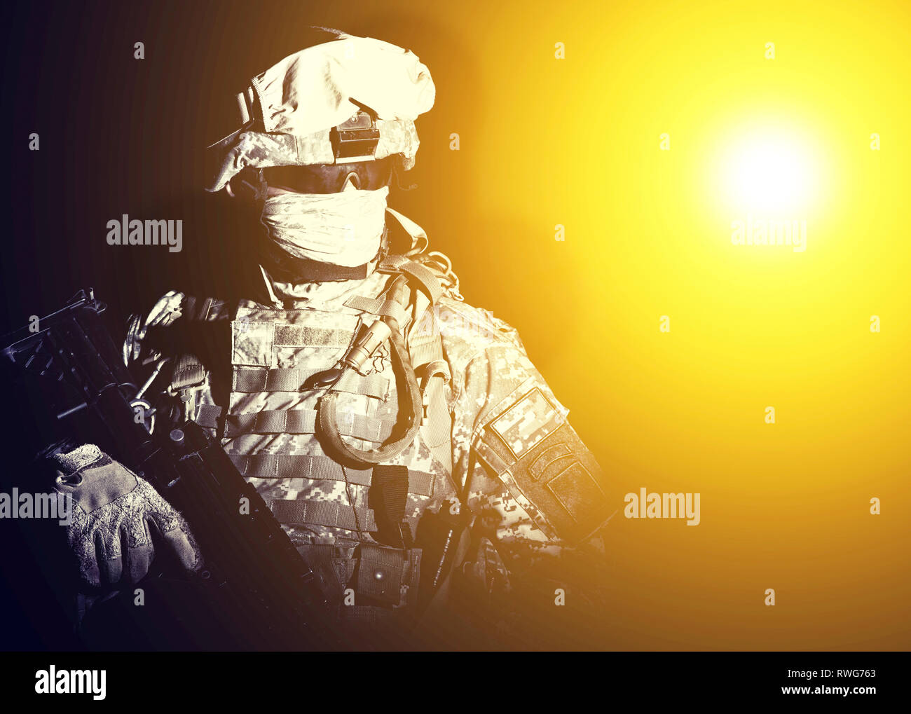 Armed infantry soldier standing in blinding light of searchlight during ...