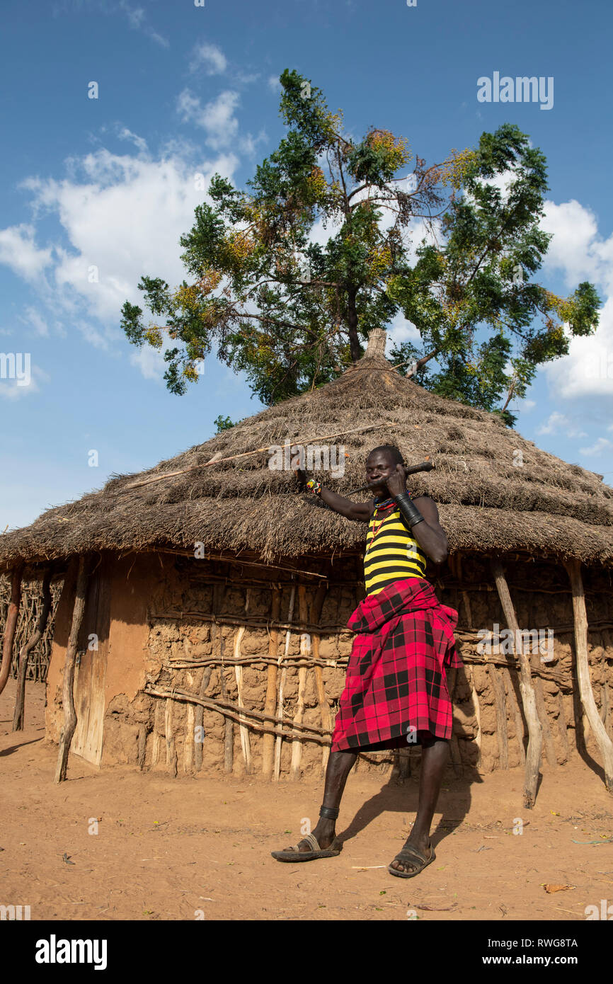 Karomojong man blowing a traditional horn, Karamojong village, northern ...