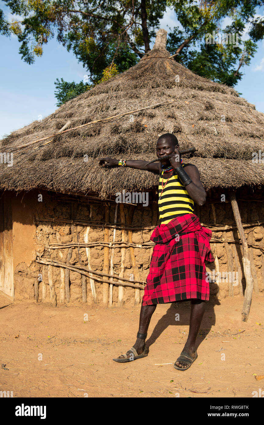 Karomojong man blowing a traditional horn, Karamojong village, northern ...
