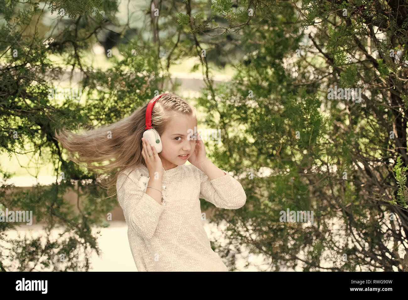 Cute little girl enjoying music using headphones at summer day Stock ...