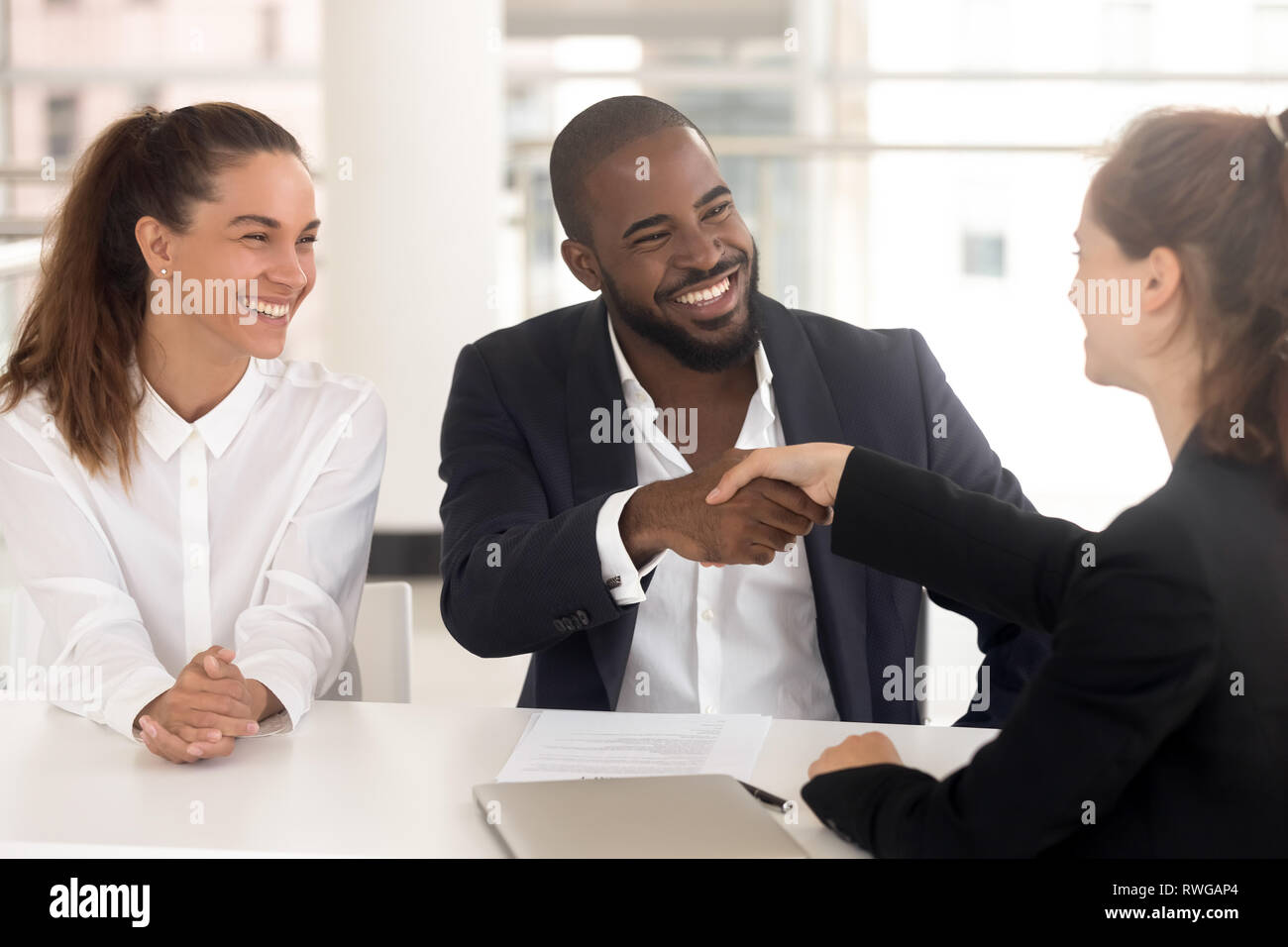 Multi-ethnic businesspeople starting job interview shaking hands Stock ...