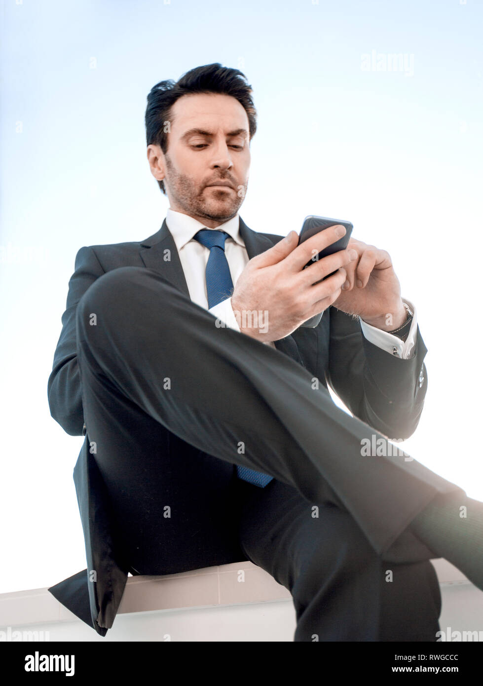 bottom view.confident businessman with smart phone Stock Photo - Alamy