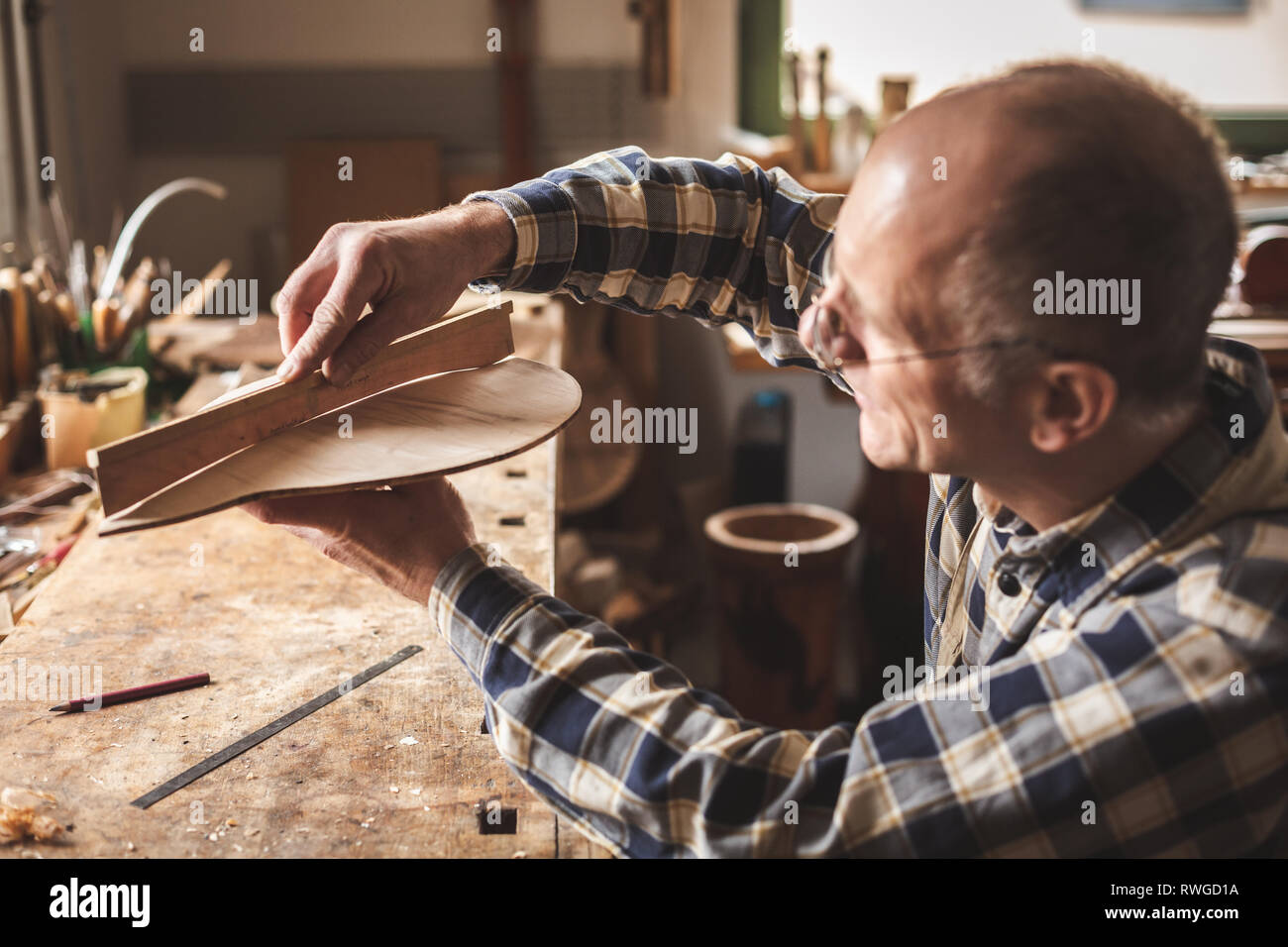 Instrument maker checking his workpiece with a wooden template Stock ...