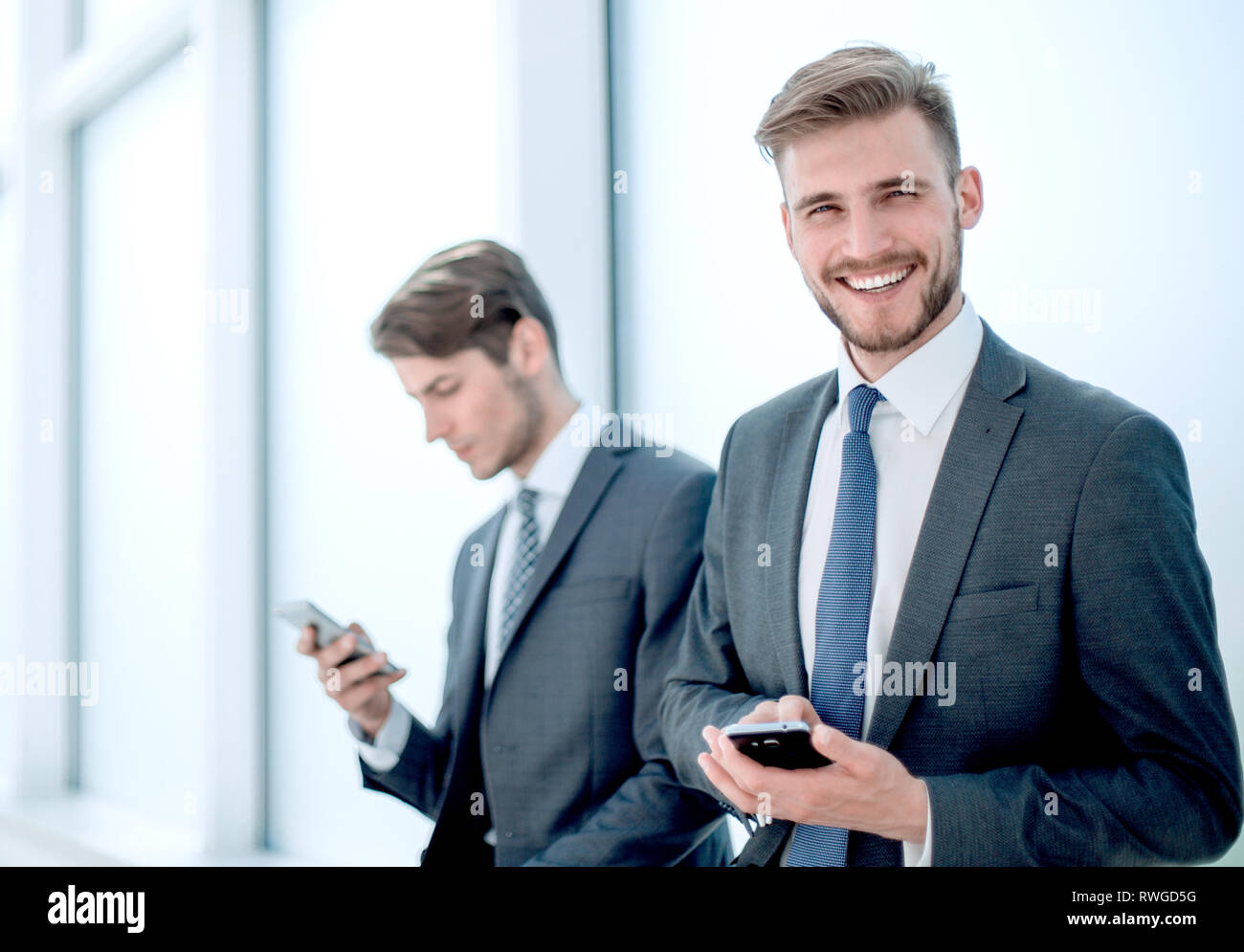 successful employees using their smartphones sitting in the office ...