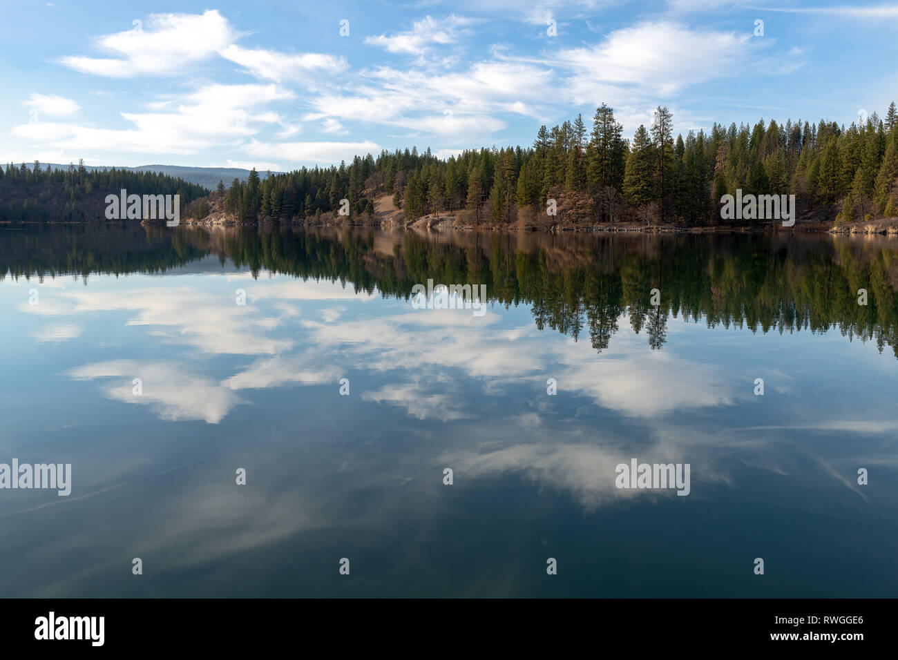 Trees and clouds reflected in Lake Britton in McArthur Burney Falls ...