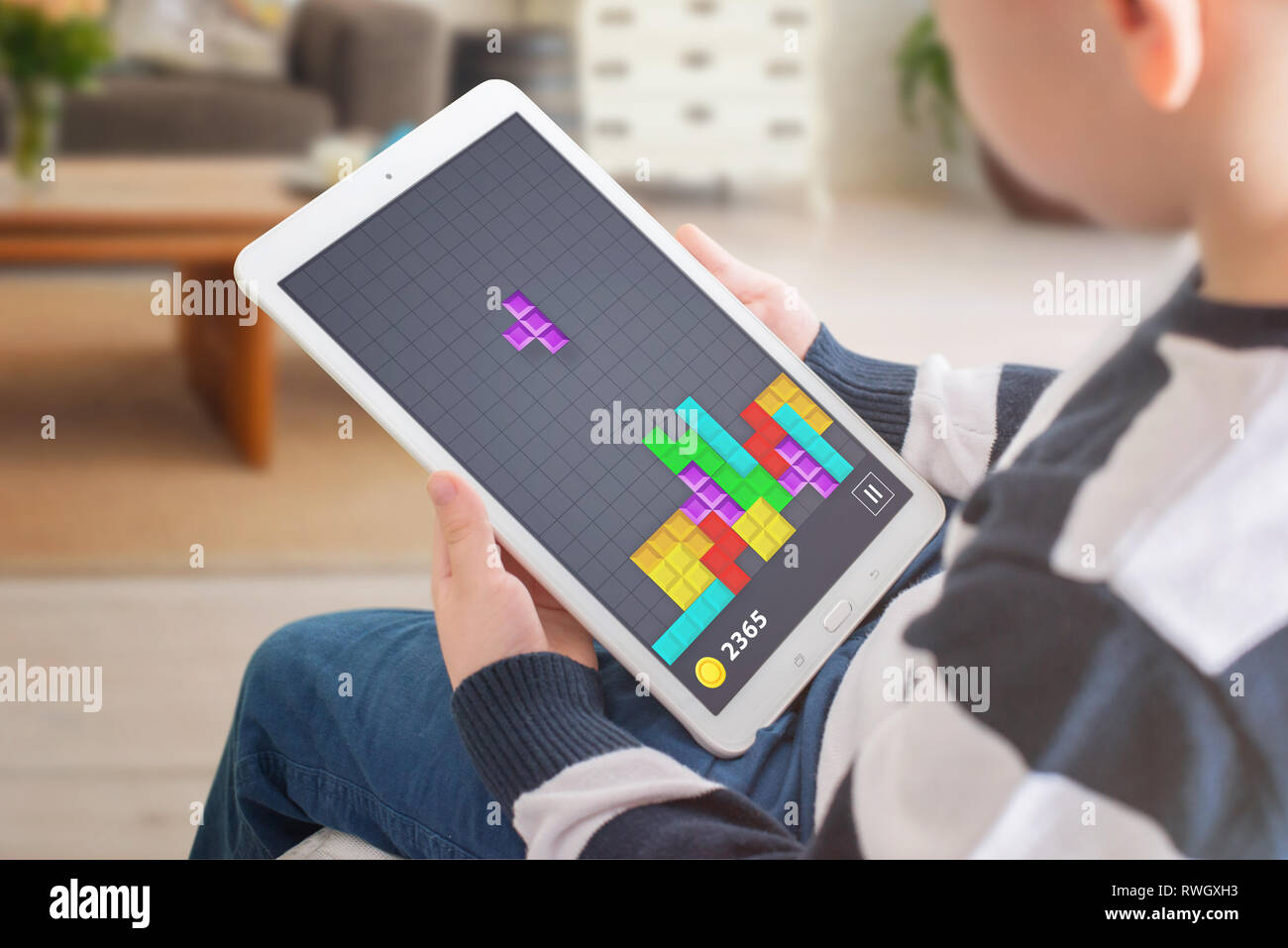 Kid play tetris game on his tablet. Entertainment for children concept ...