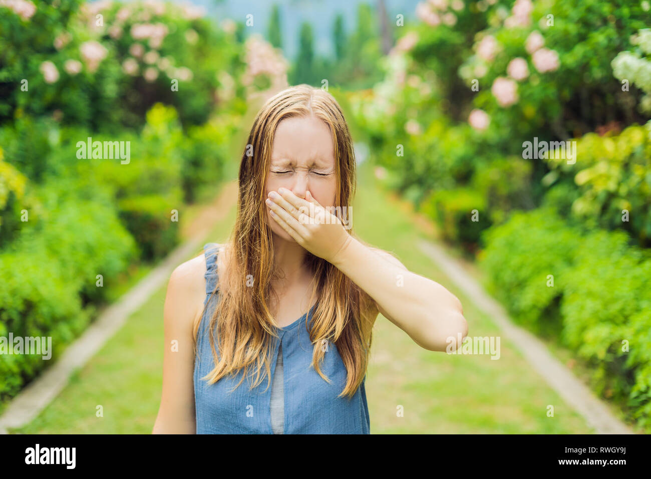 Young pretty woman blowing nose in front of blooming tree. Spring allergy concept Stock Photo ...