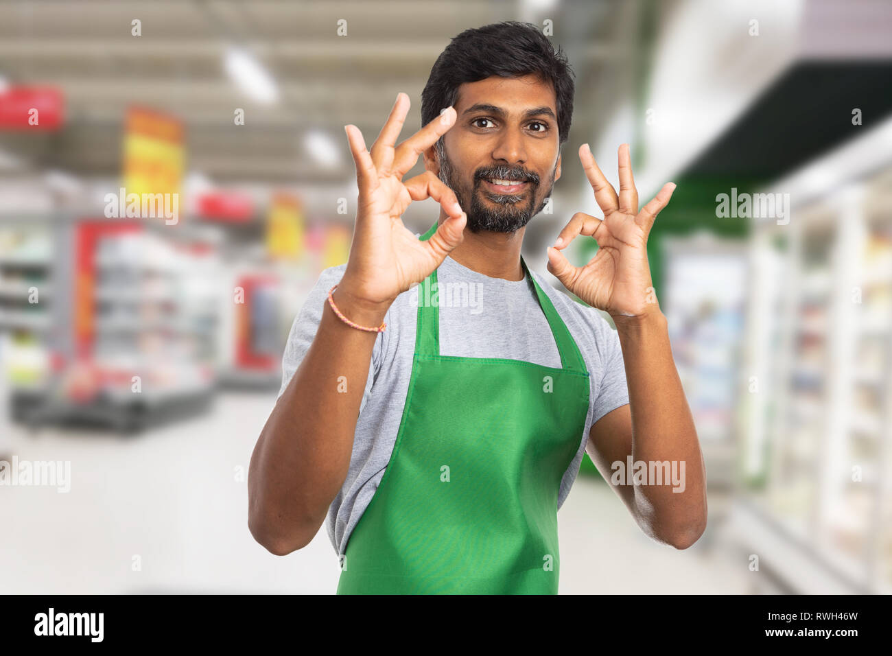 Friendly indian male storekeeper or hypermarket employee holding ...
