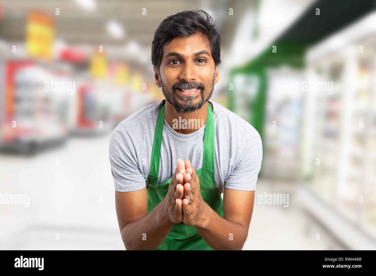Indian worker man at supermarket or hypermarket with joint hands as ...