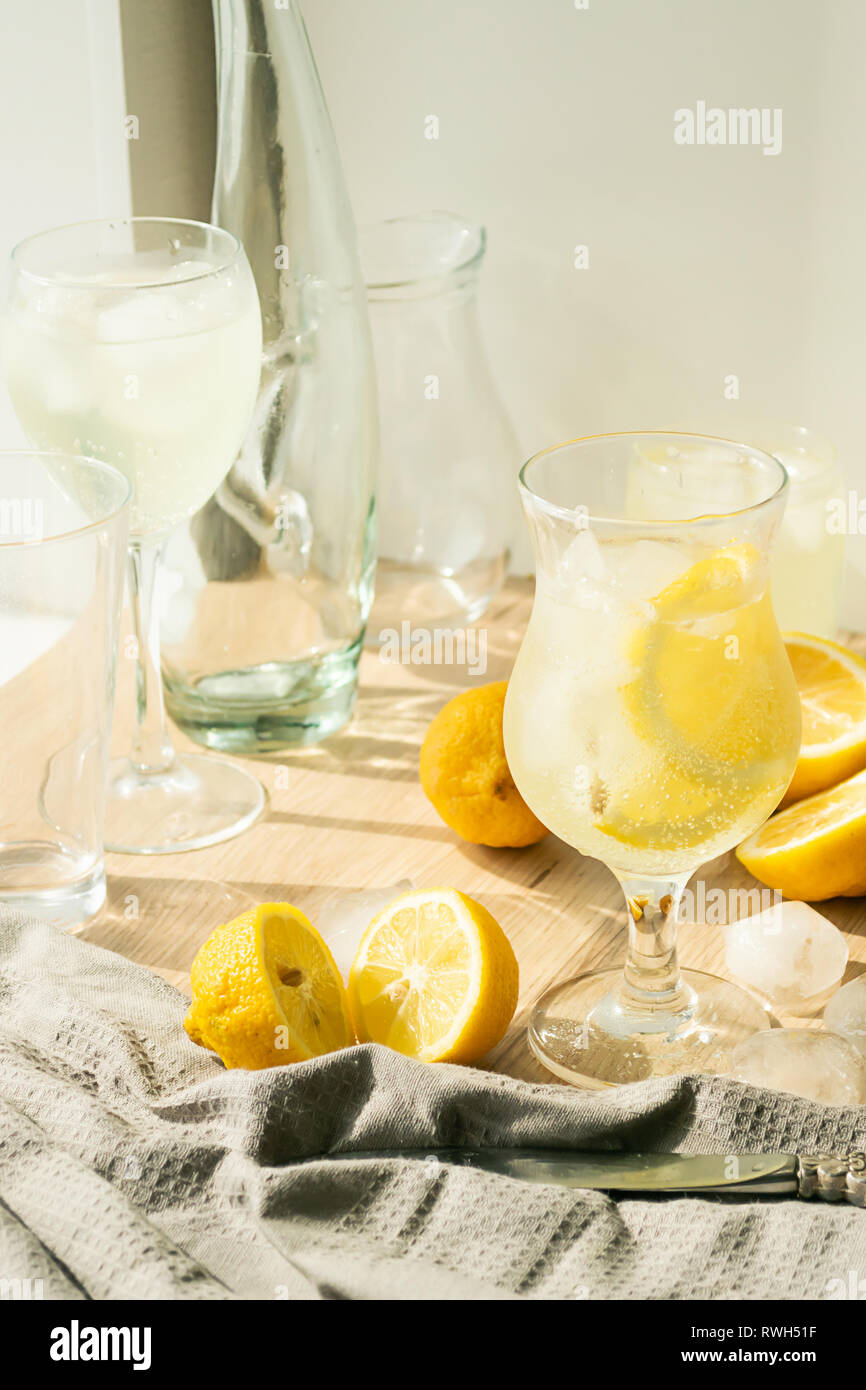 Summer refreshing drink of fresh lemon and ice cubes in a transparent ...