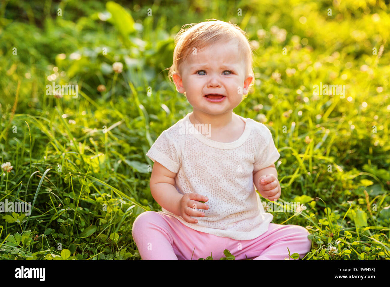 Portrait of crying screaming cute baby toddler outdoor. Sweet unhappy ...