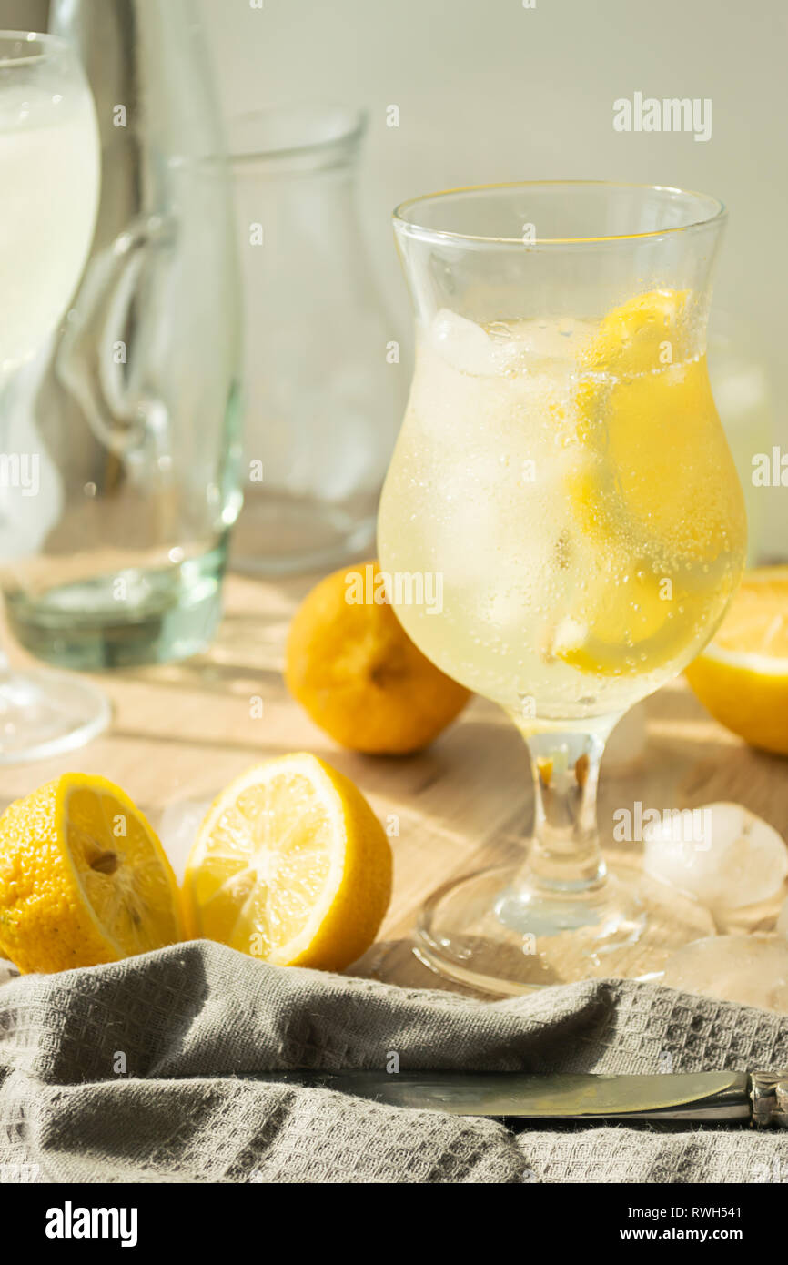 Summer refreshing drink of fresh lemon and ice cubes in a transparent ...