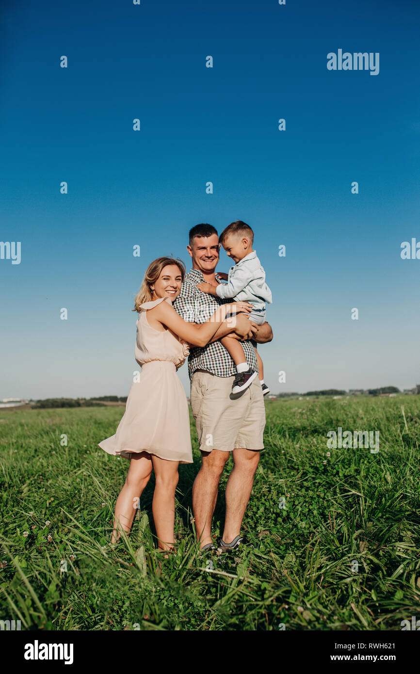 Family walking in field carrying young baby boy Stock Photo - Alamy