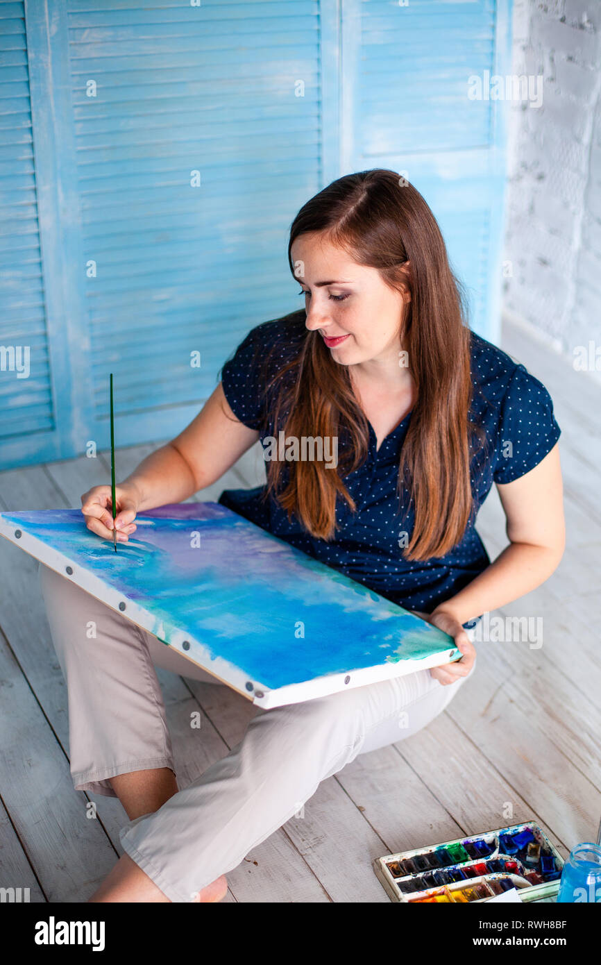 Female artist with brush and paint palette on color background Stock ...