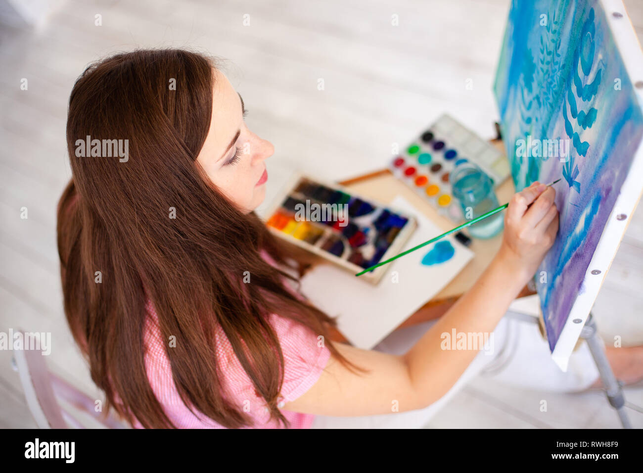 Portrait of a gorgeous female artist working on several art projects on ...