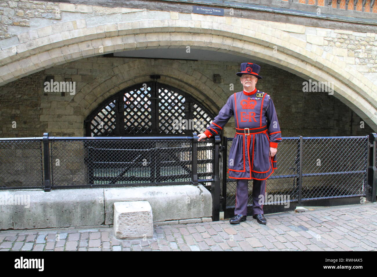 A Beefeater stands in front of Traitors Gate at The Tower of London ...
