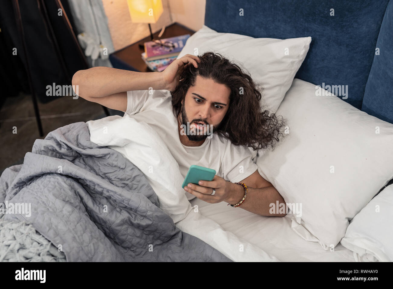 Cheerless young man waking up too late Stock Photo - Alamy