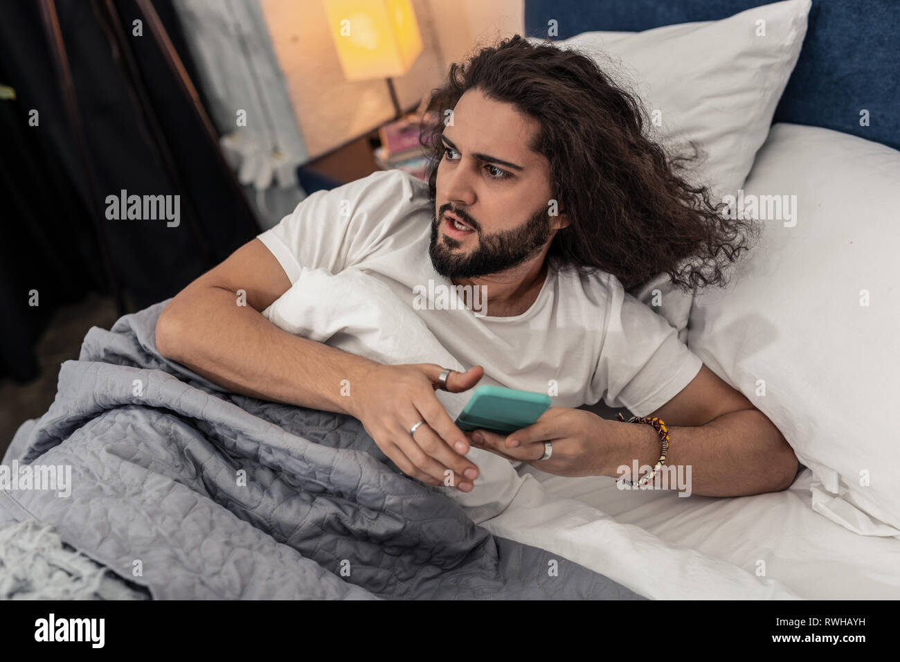 Nice long haired man being ready to get up Stock Photo - Alamy