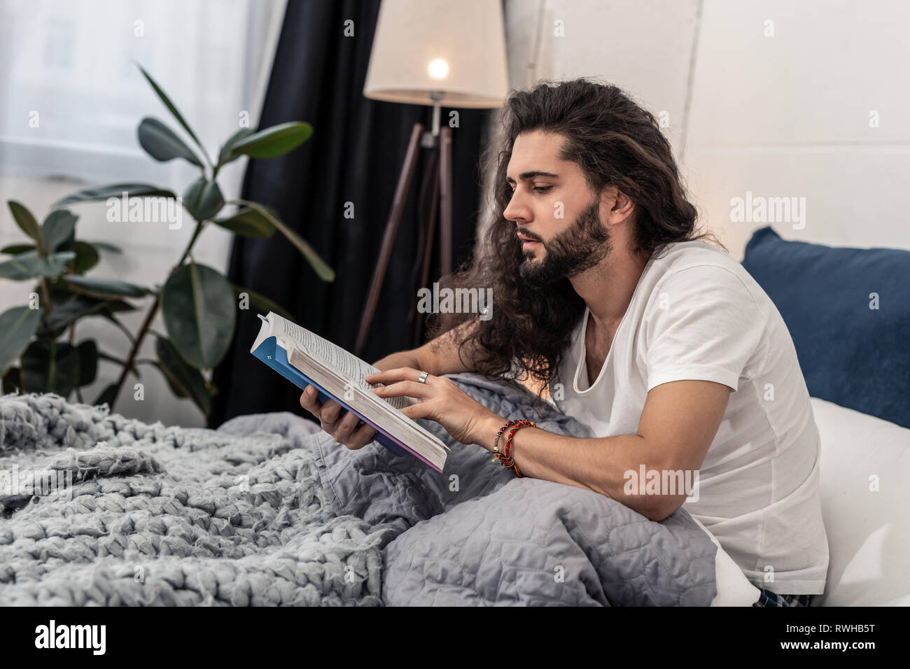 Nice handsome man reading his favourite book Stock Photo - Alamy