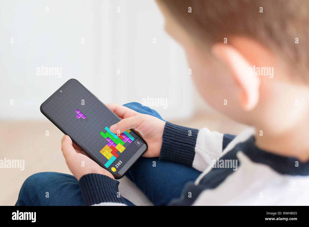 Child play game on smart phone. Game with modern flat interface. View ...
