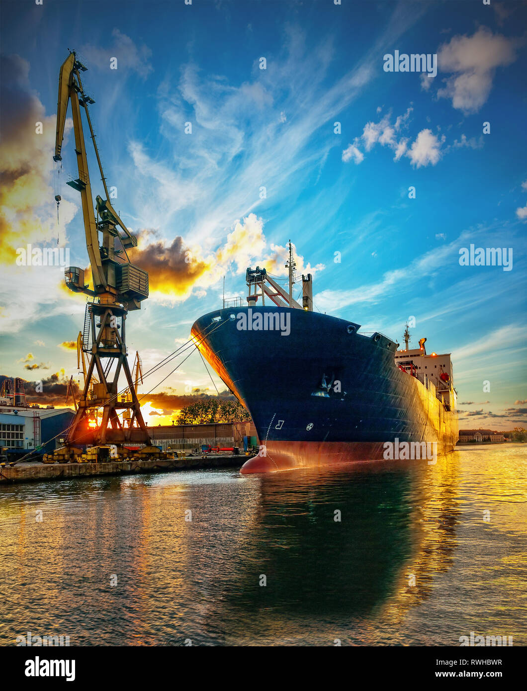 Cargo ship in port at sunset time Stock Photo - Alamy