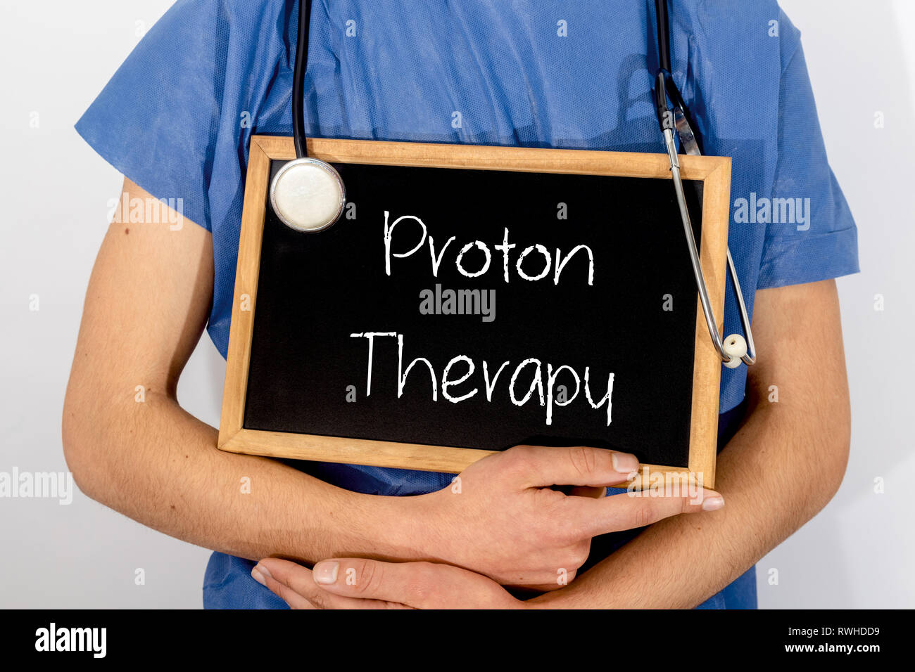Doctor shows information on blackboard: proton therapy. Medical concept ...