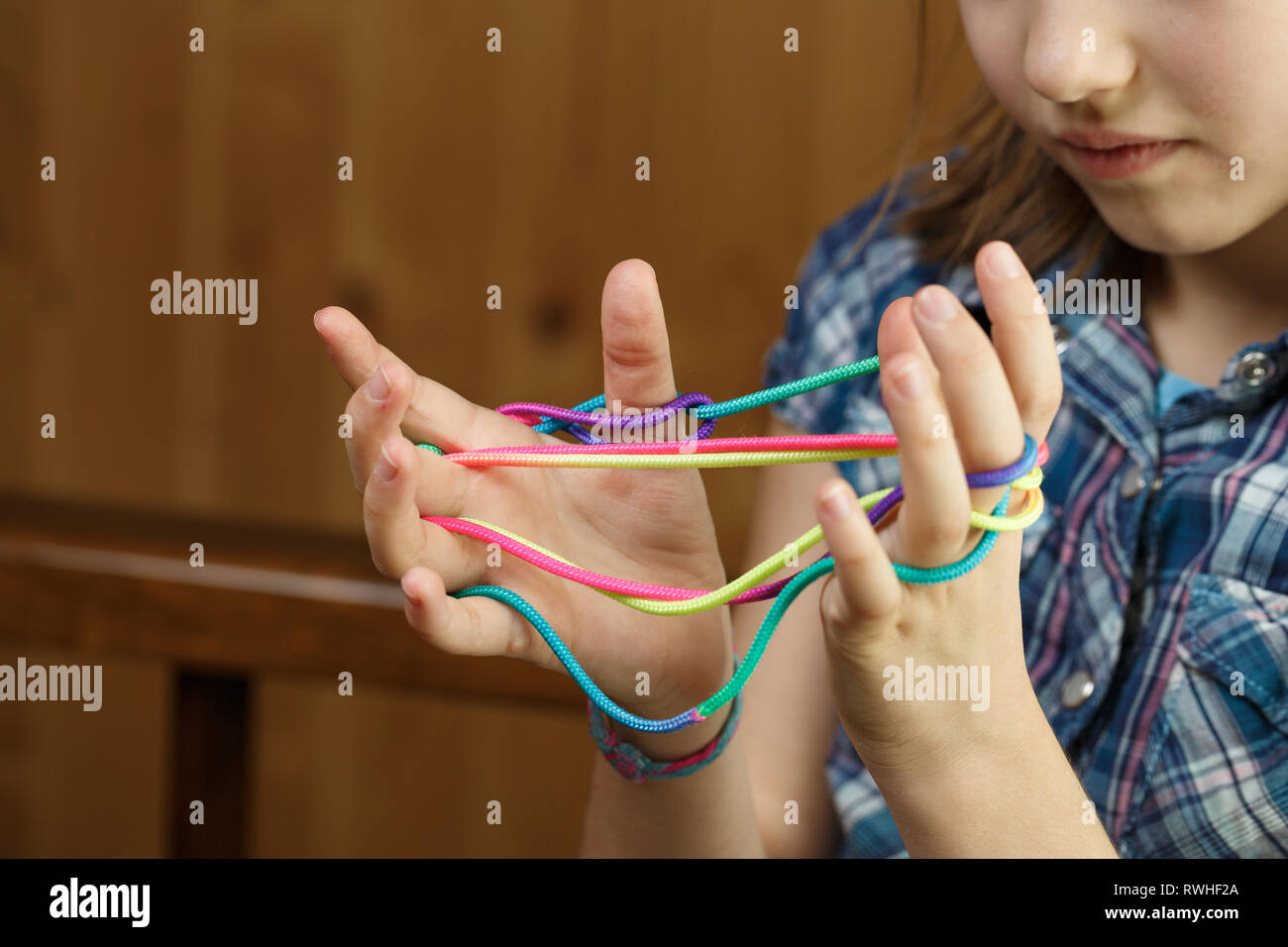 Child playing classic, old-school string game and didactic toy with her ...