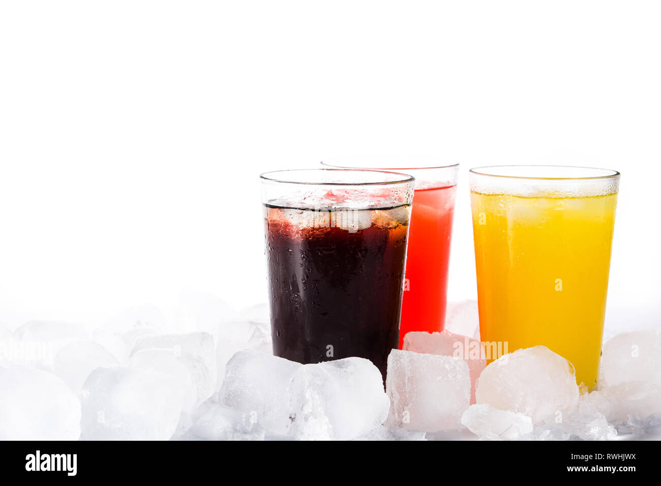 Colorful soft drinks for summer with ice cubes on white background ...