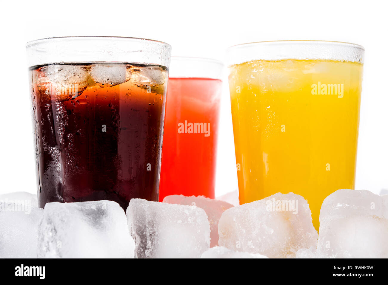 Colorful soft drinks for summer with ice cubes on white background ...