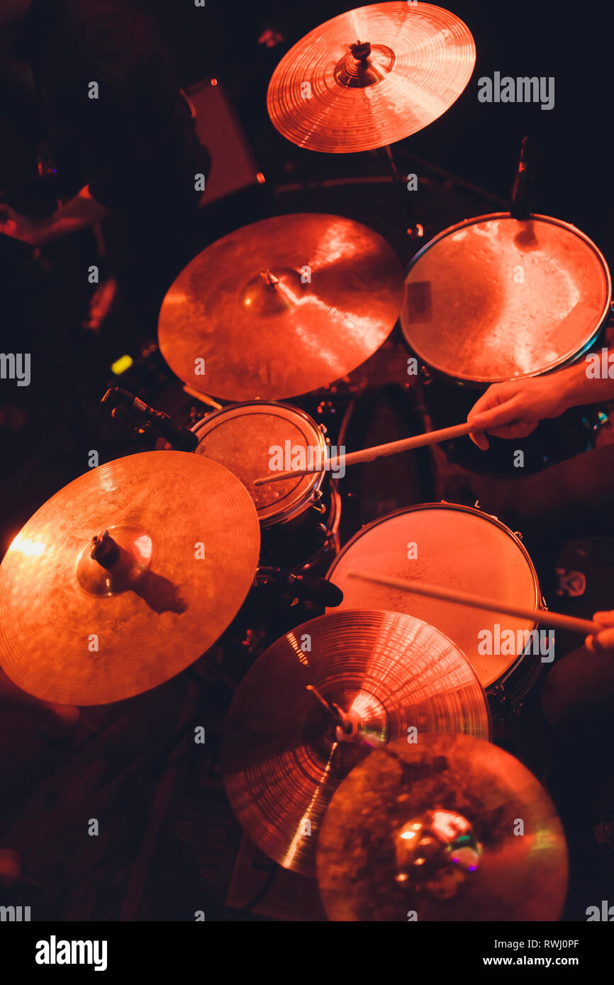 man plays musical percussion instrument with sticks closeup on a black ...