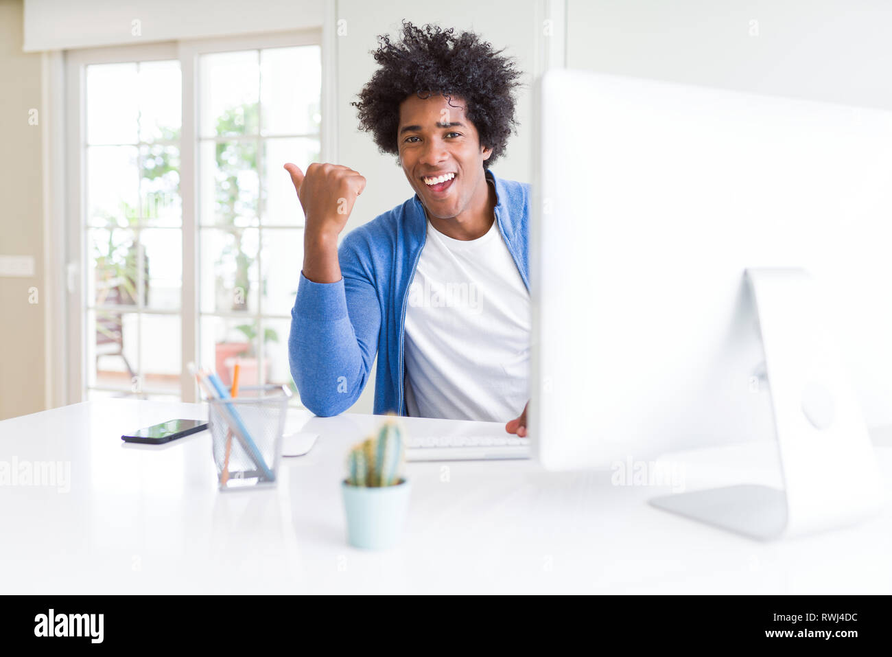 African American man working using computer pointing and showing with ...