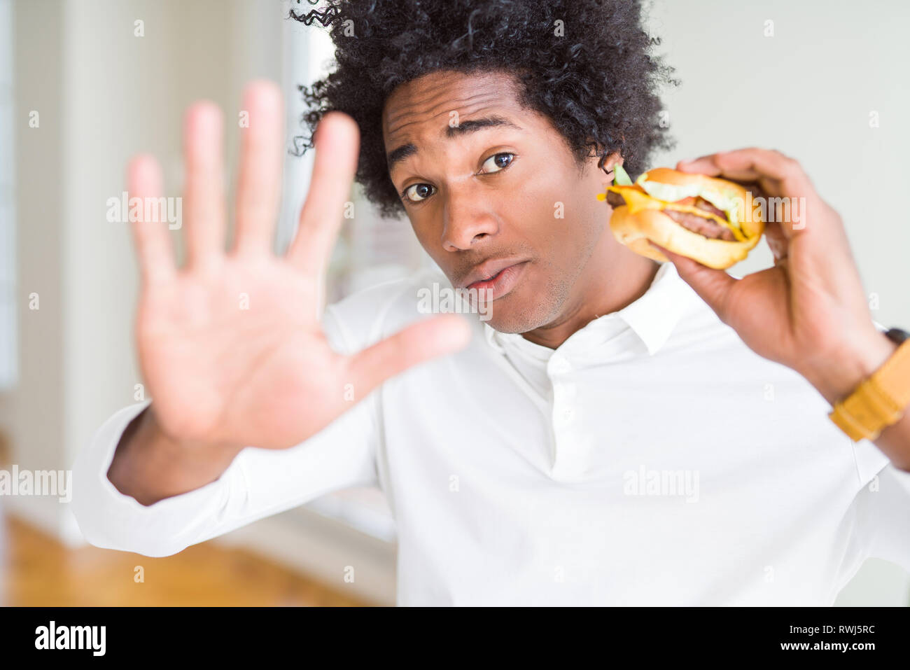 African American hungry man eating hamburger for lunch with open hand ...