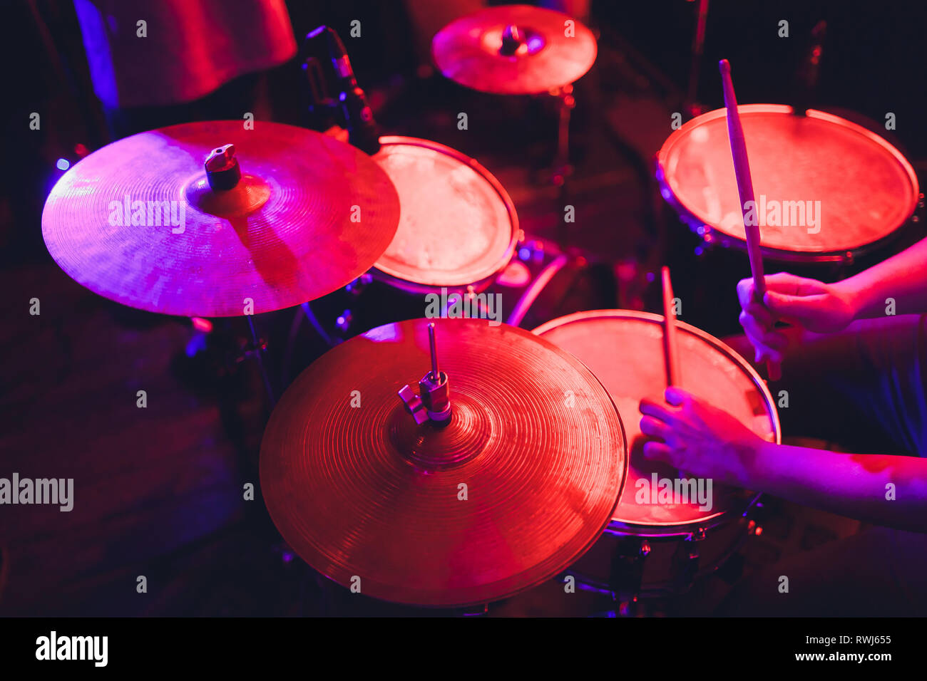 man plays musical percussion instrument with sticks closeup on a black ...
