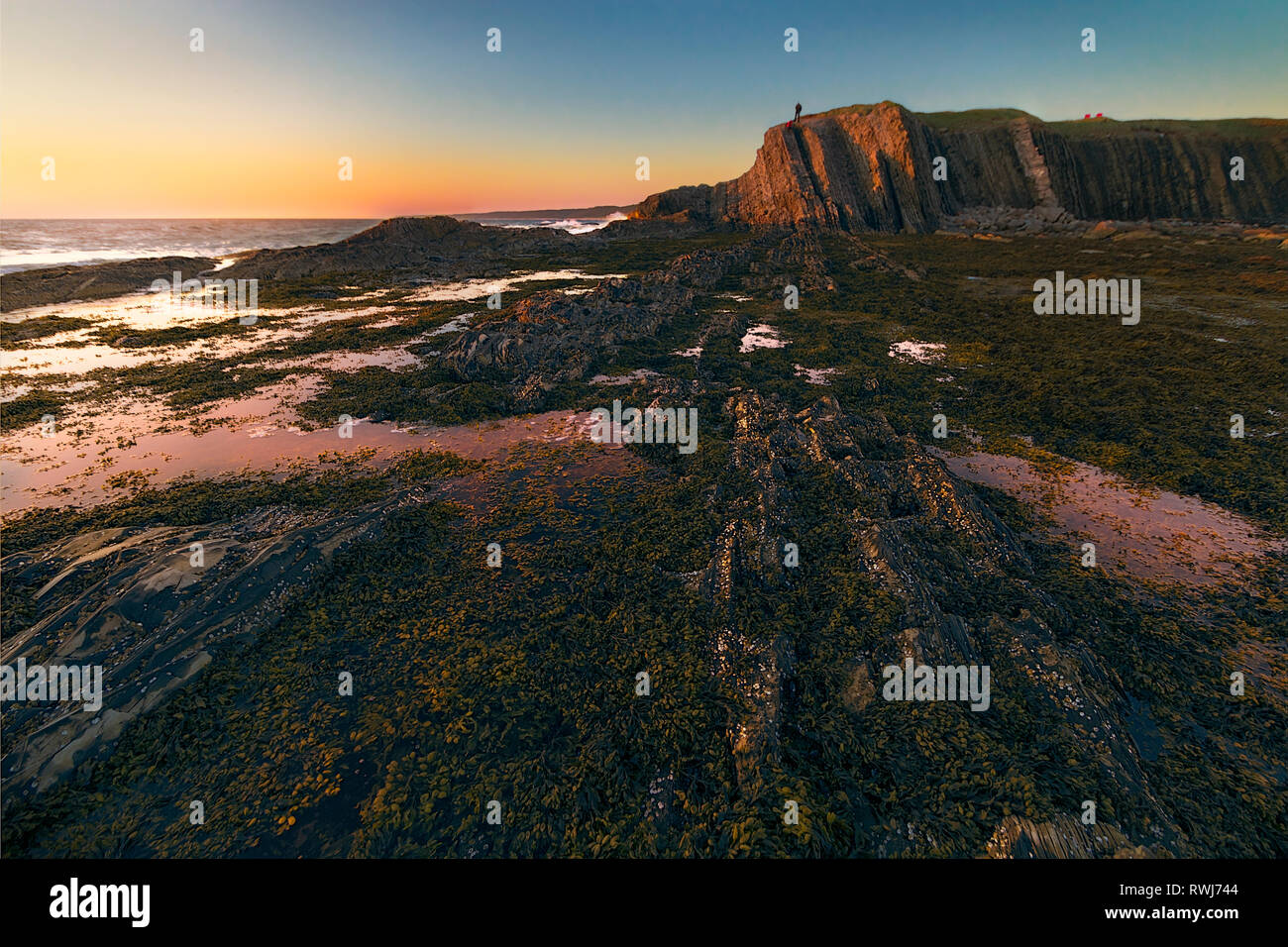Sun dropping below the horizion at Green Point, Gros Morne National ...