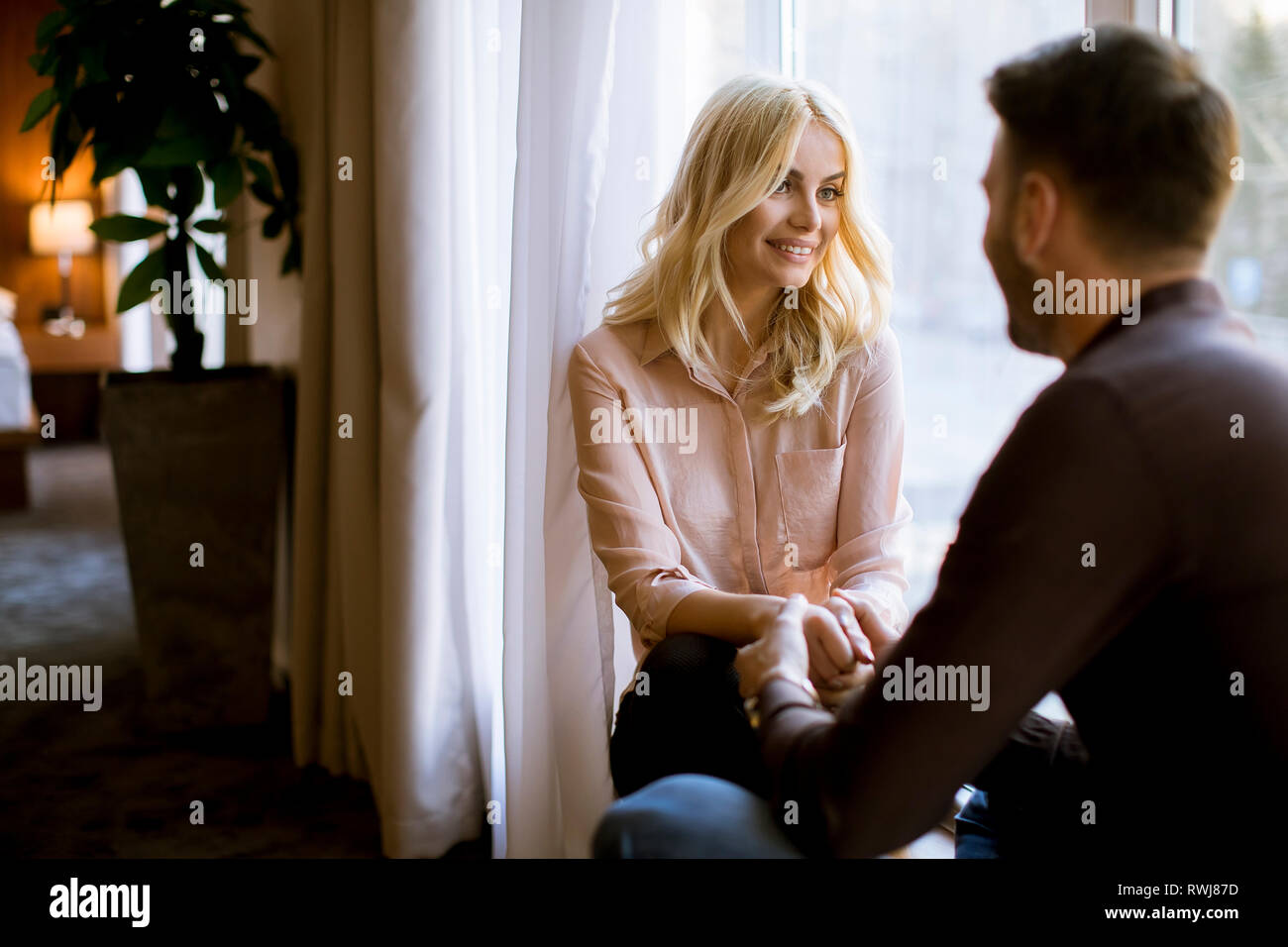 Happy loving couple near window in the room Stock Photo - Alamy